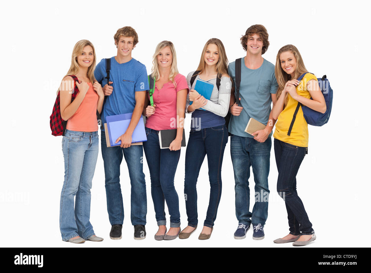 Smiling students wearing backpacks and holding books in their hands ...