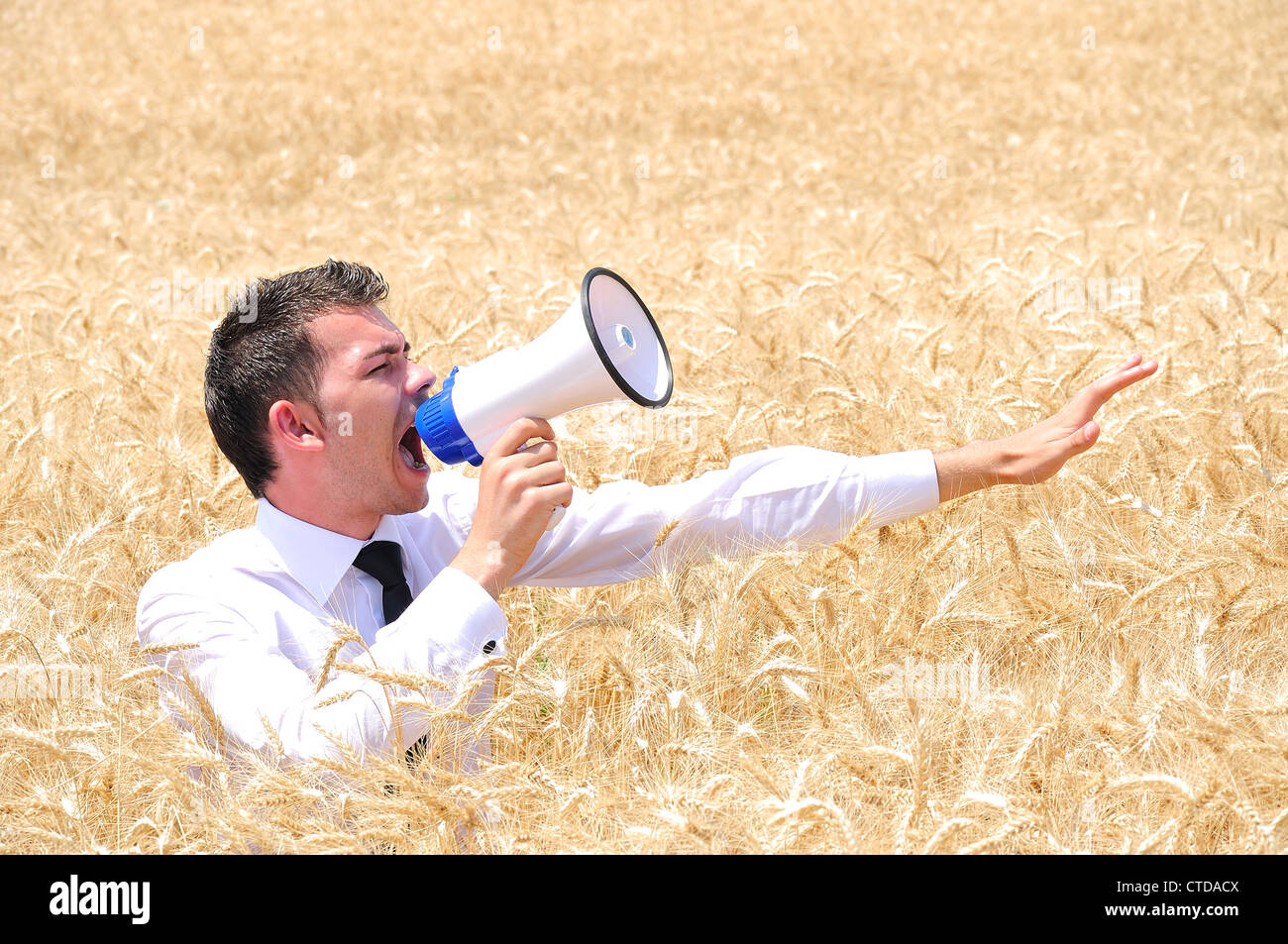Business man with loudspeaker in wheat Stock Photo - Alamy