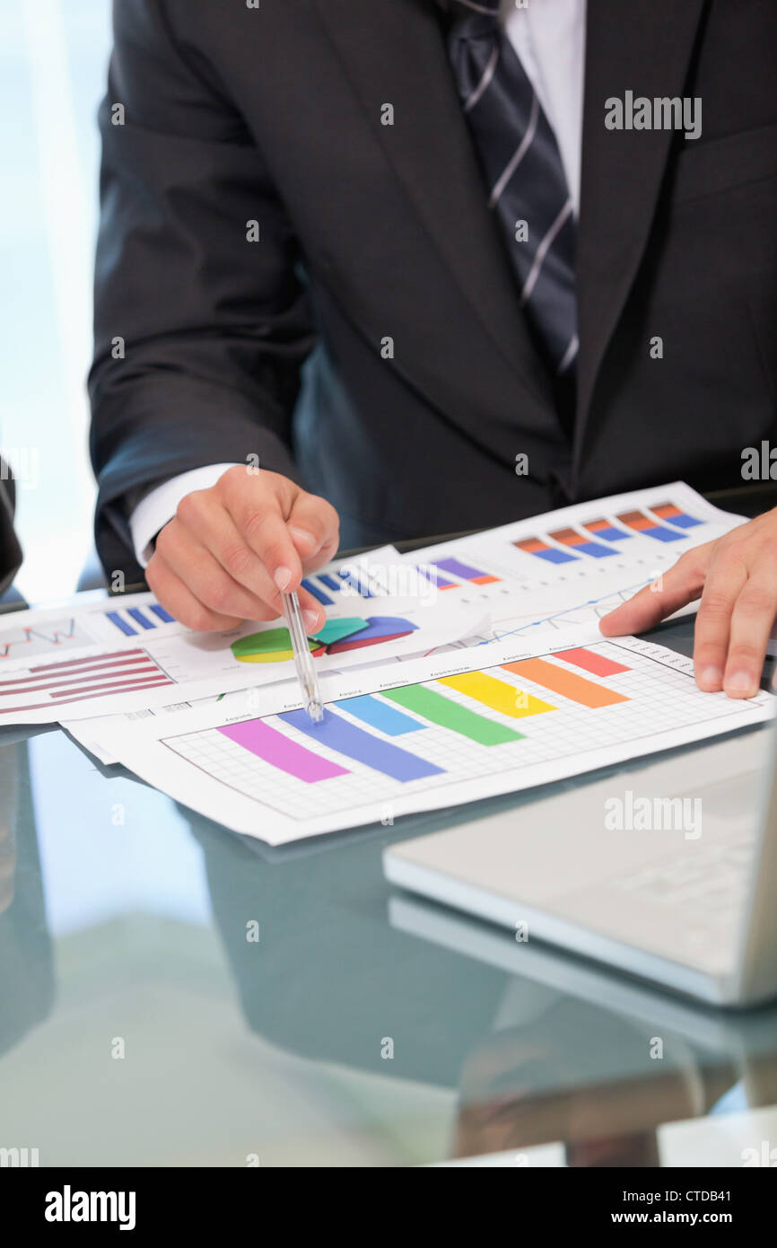 Men pointing a graph with a pen Stock Photo - Alamy