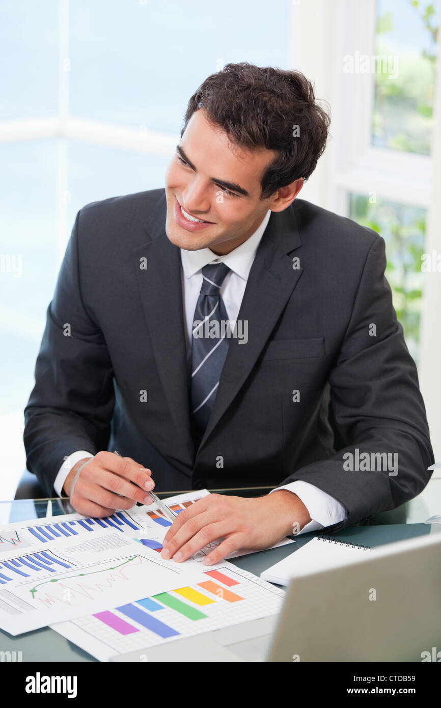 Man pointing out a graph while looking away Stock Photo - Alamy