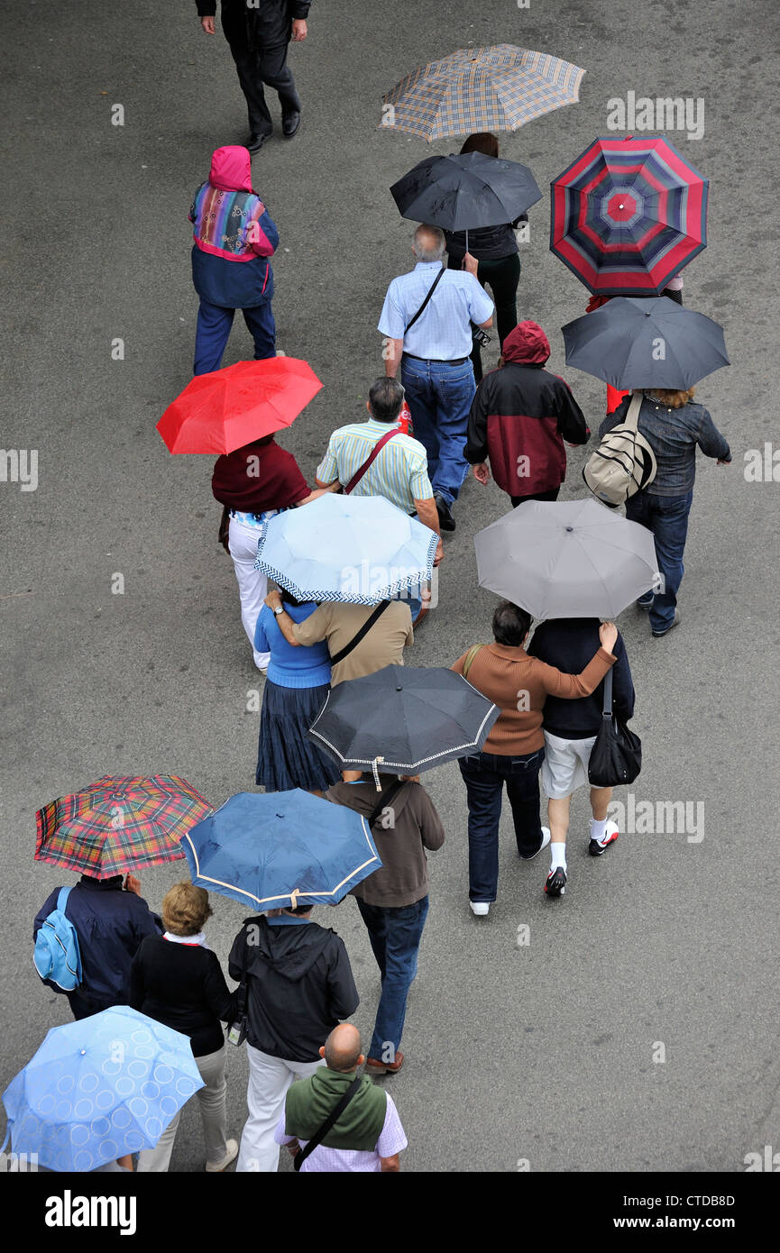 People with umbrellas walking in the rain on a rainy wet day in summer ...