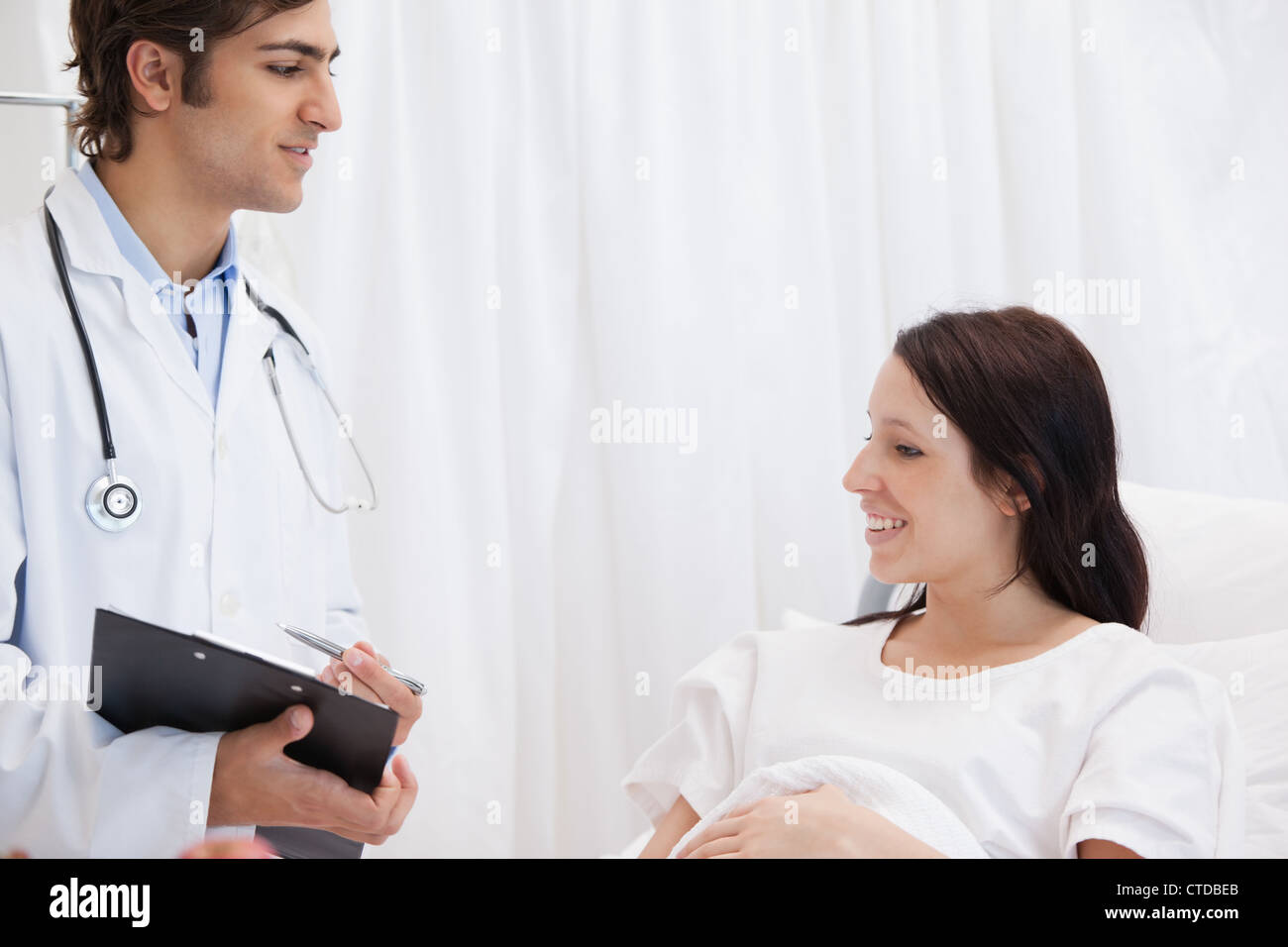 Patient smiling while talking to a doctor Stock Photo - Alamy