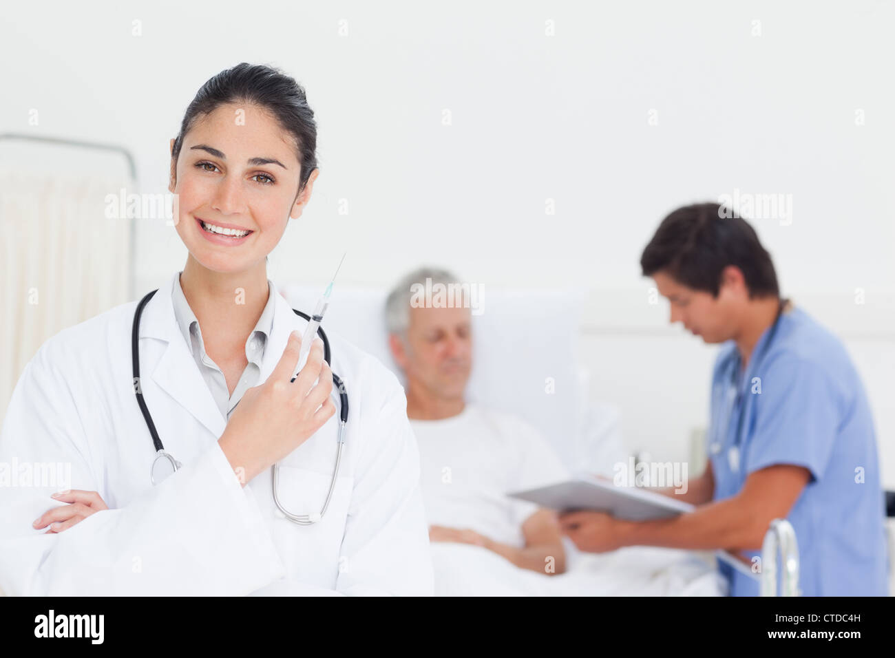 Smiling doctor holding a syringe Stock Photo - Alamy
