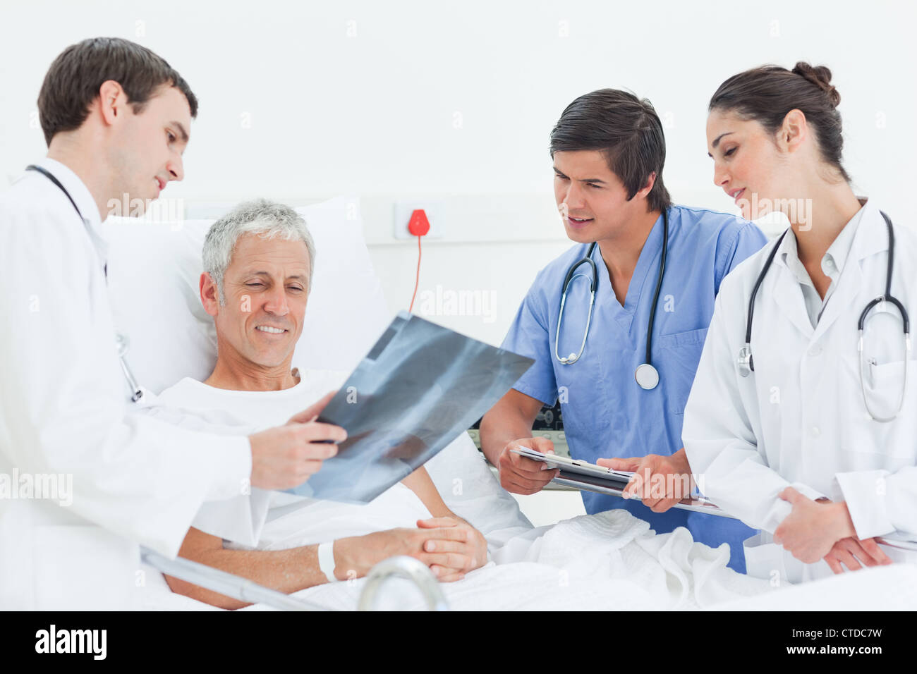 Patient smiling as he is being shown an x-ray scan by a doctor Stock ...
