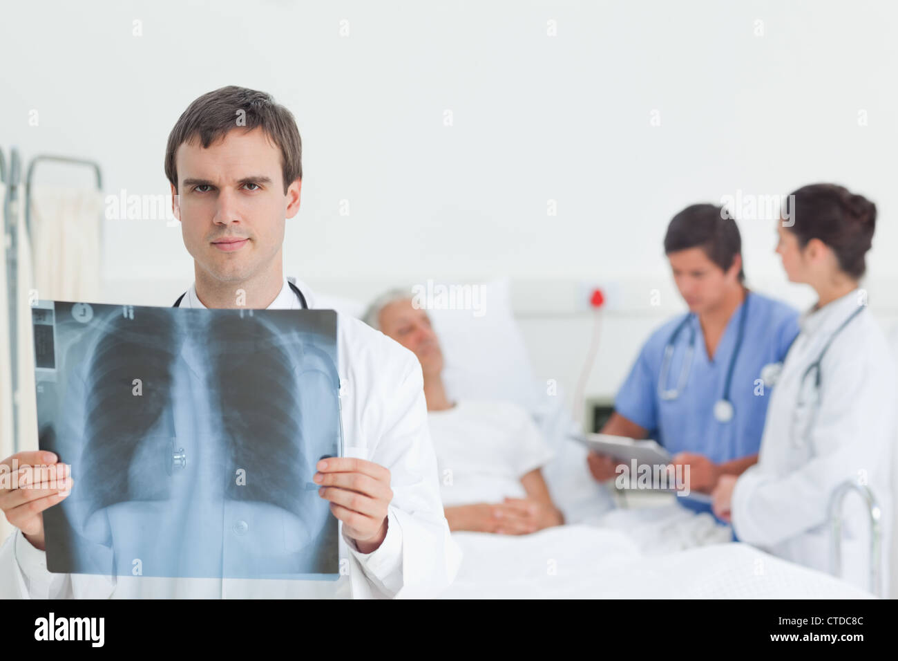 Doctor looking ahead while holding an x-ray scan Stock Photo - Alamy