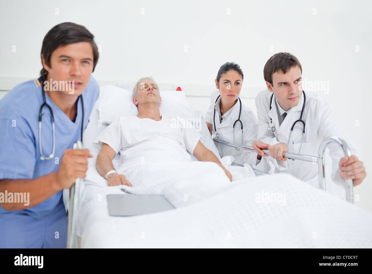 Nurse and two doctors pushing a hospital bed Stock Photo - Alamy