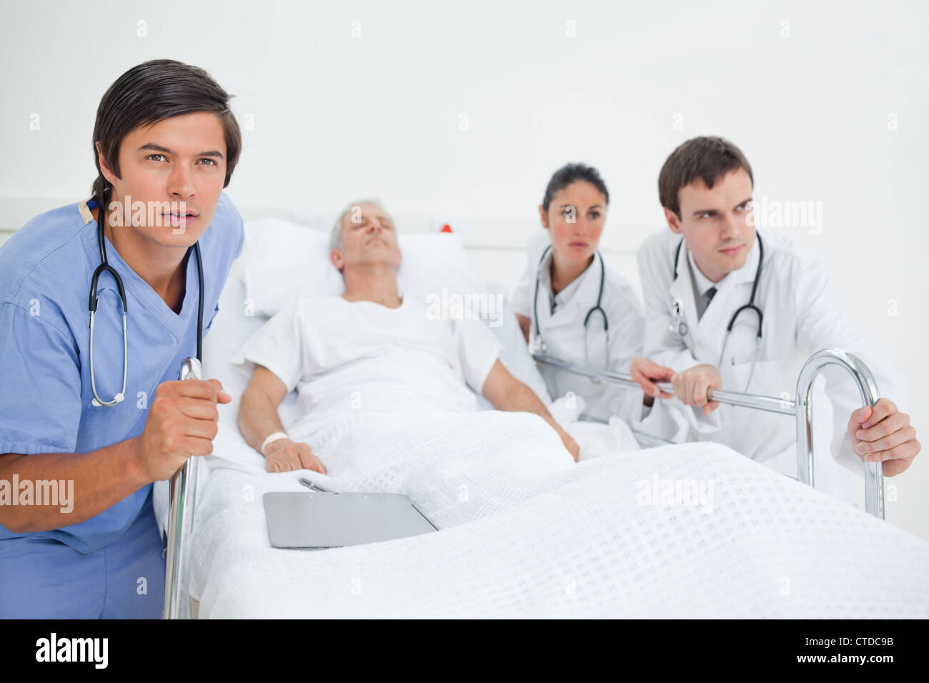 Serious nurse and doctors pushing a hospital bed Stock Photo - Alamy