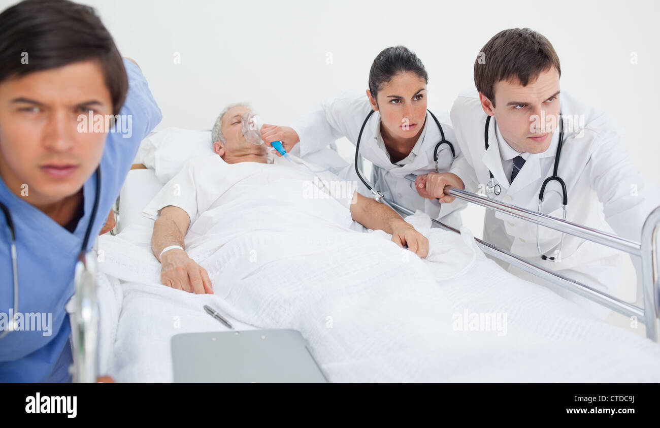Two doctors look ahead as they push a hospital bed with the help of a ...