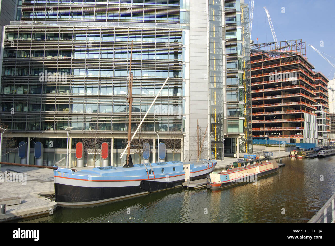 Modern buildings, construction site and canal boats in Paddington ...