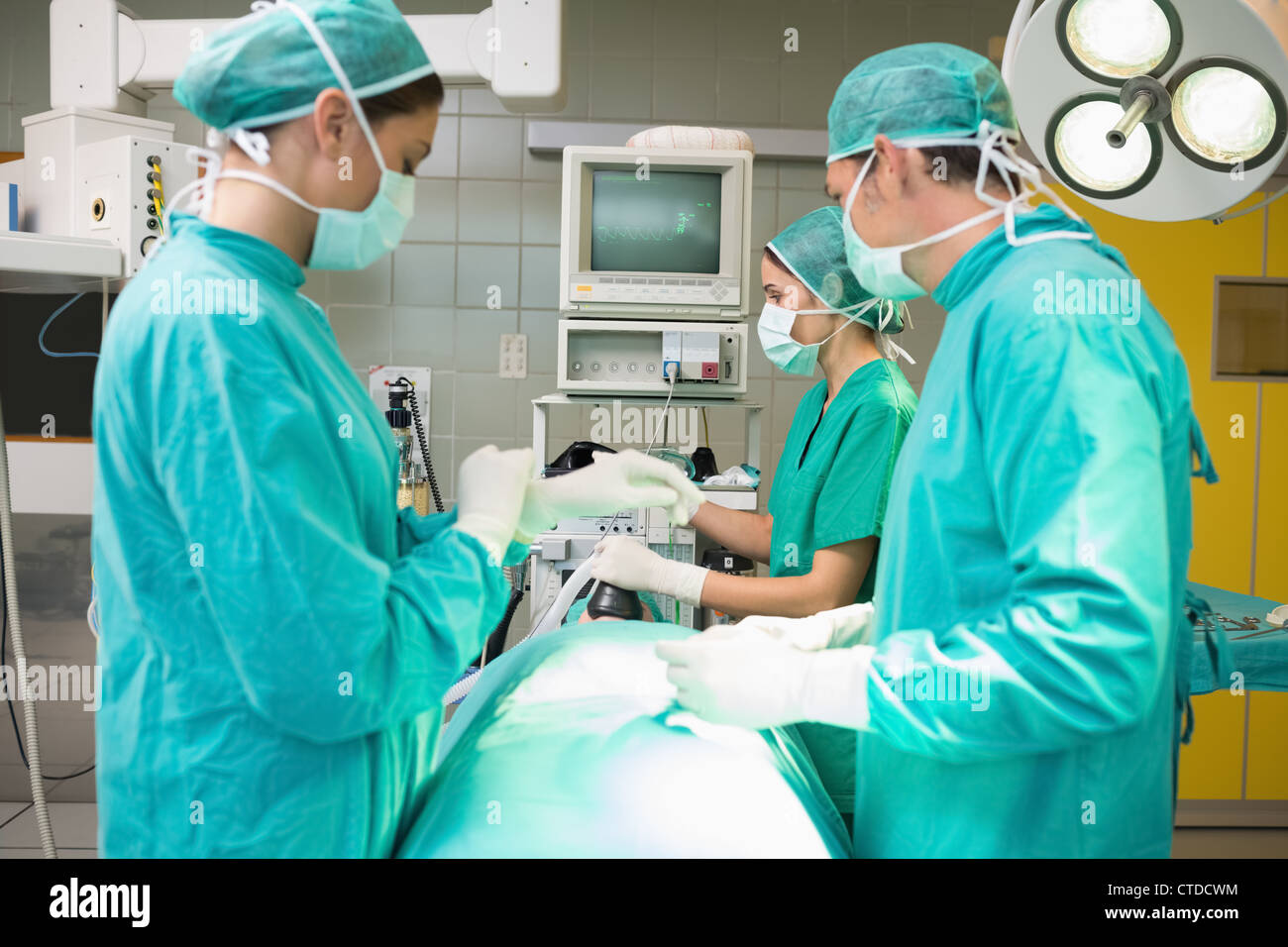 Side view of a surgical team operating Stock Photo - Alamy