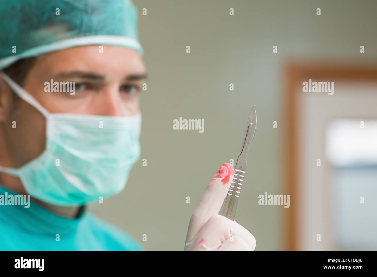 Surgeon holding a scalpel Stock Photo - Alamy