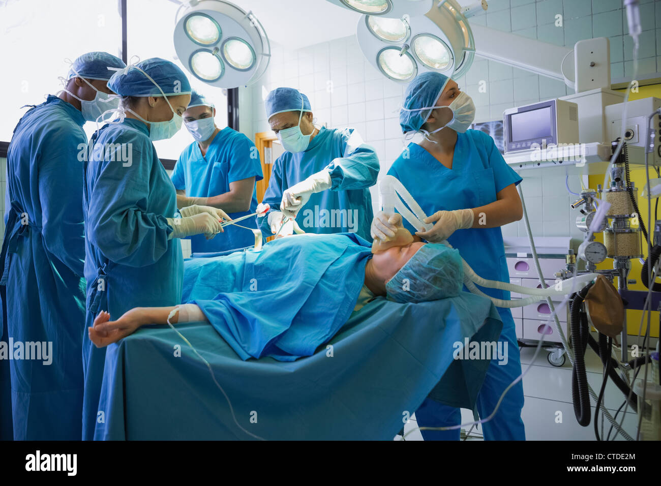 Team of hospital surgeons operating a patient Stock Photo - Alamy
