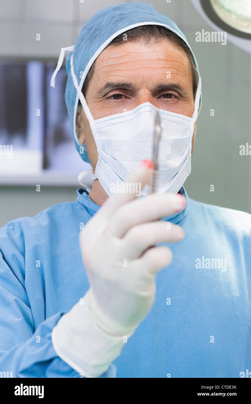 Male surgeon holding a scalpel in his hand Stock Photo - Alamy