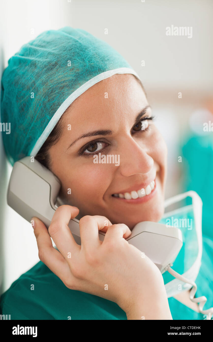 Female surgeon smiling on the phone in a hallway Stock Photo - Alamy