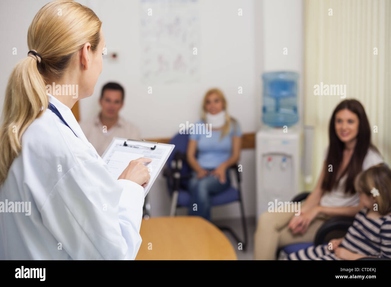 Female doctor talking to patient in a waiting room Stock Photo - Alamy