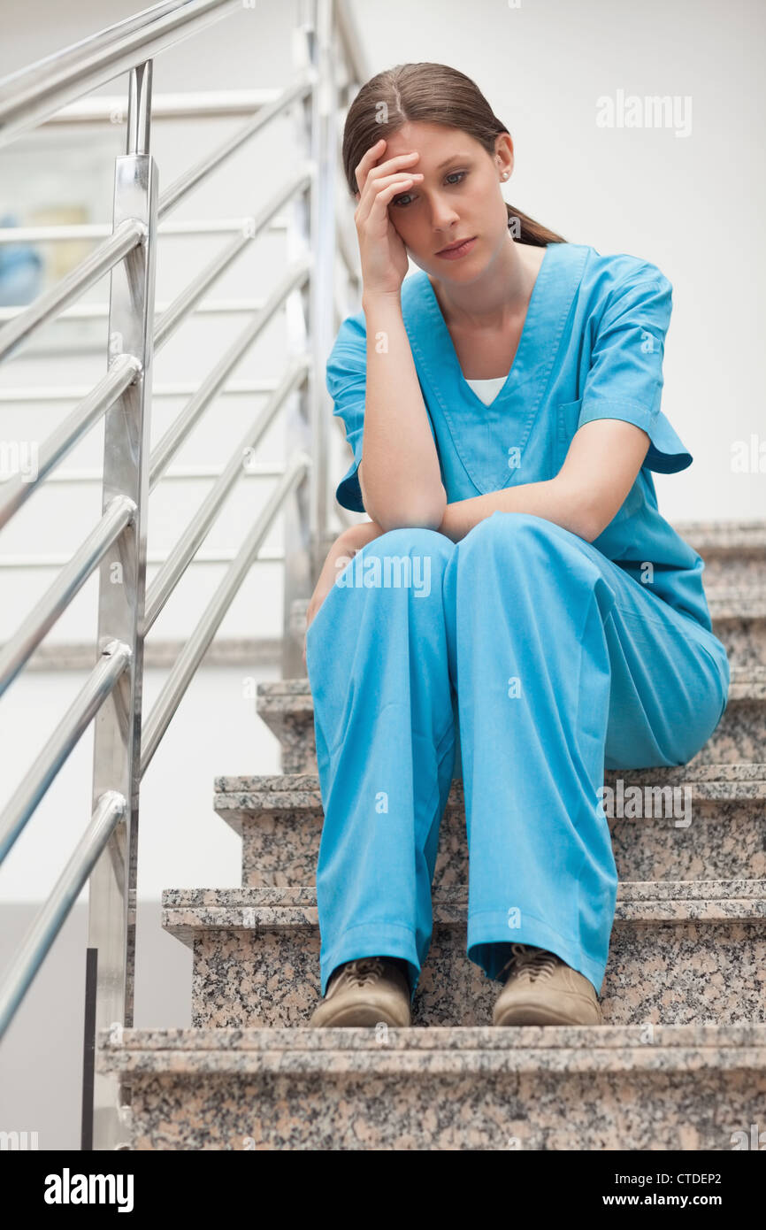 Thinking woman sitting on stairs Stock Photo - Alamy