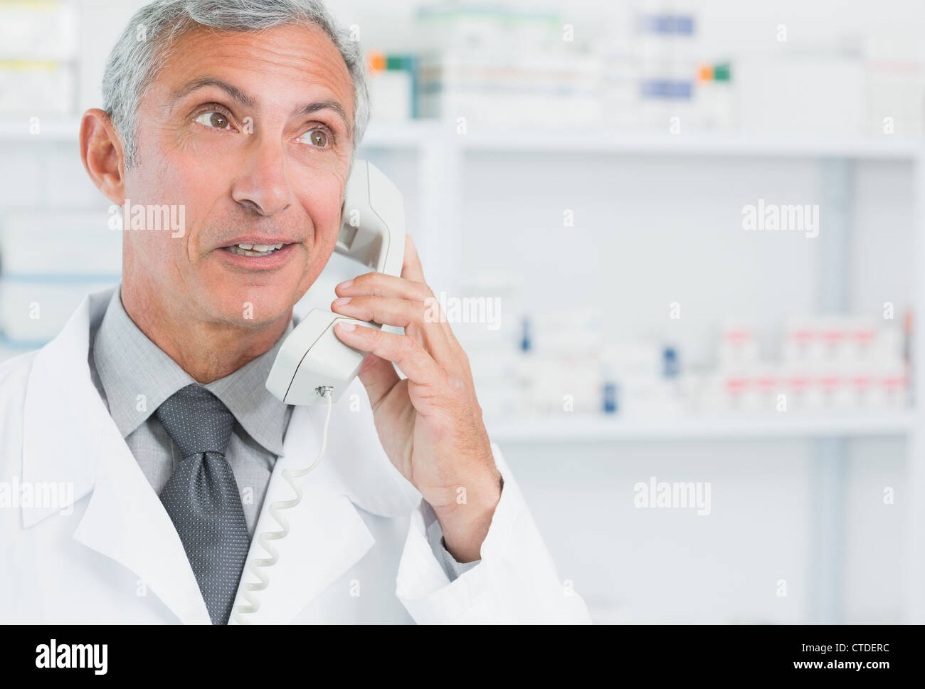Pharmacist talking on the phone in a pharmacy Stock Photo - Alamy