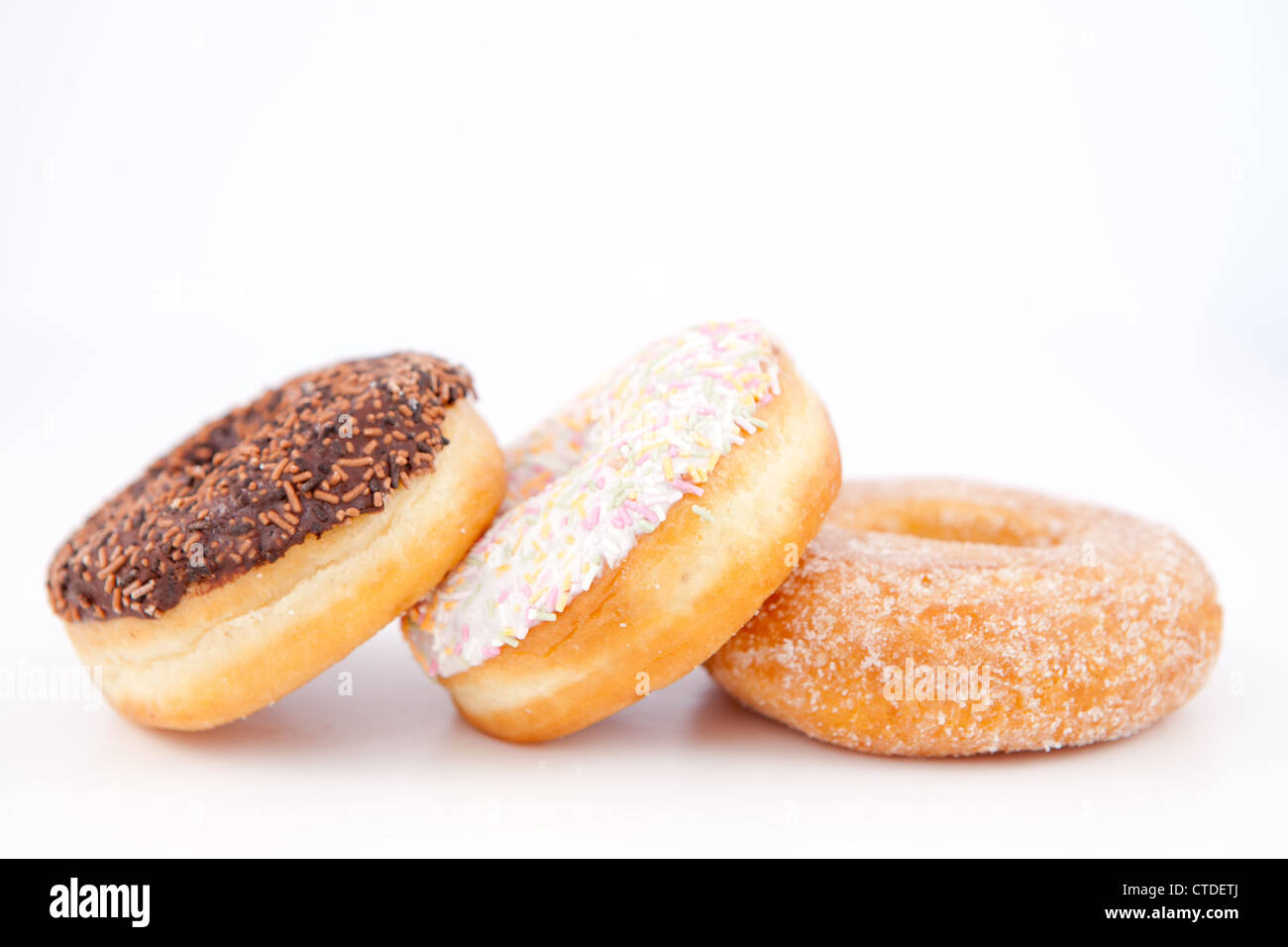 Three doughnuts with icing sugar lined up Stock Photo - Alamy