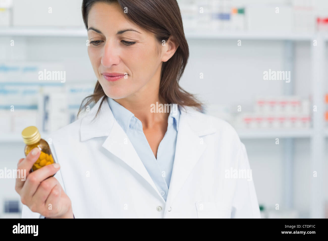 Female pharmacist looking at pills in a pharmacy Stock Photo - Alamy