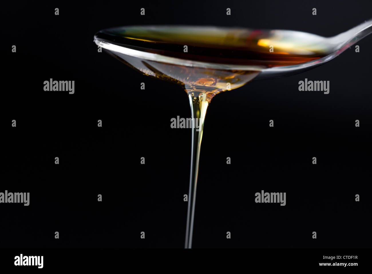 Honey trickle dropping of a spoon Stock Photo - Alamy