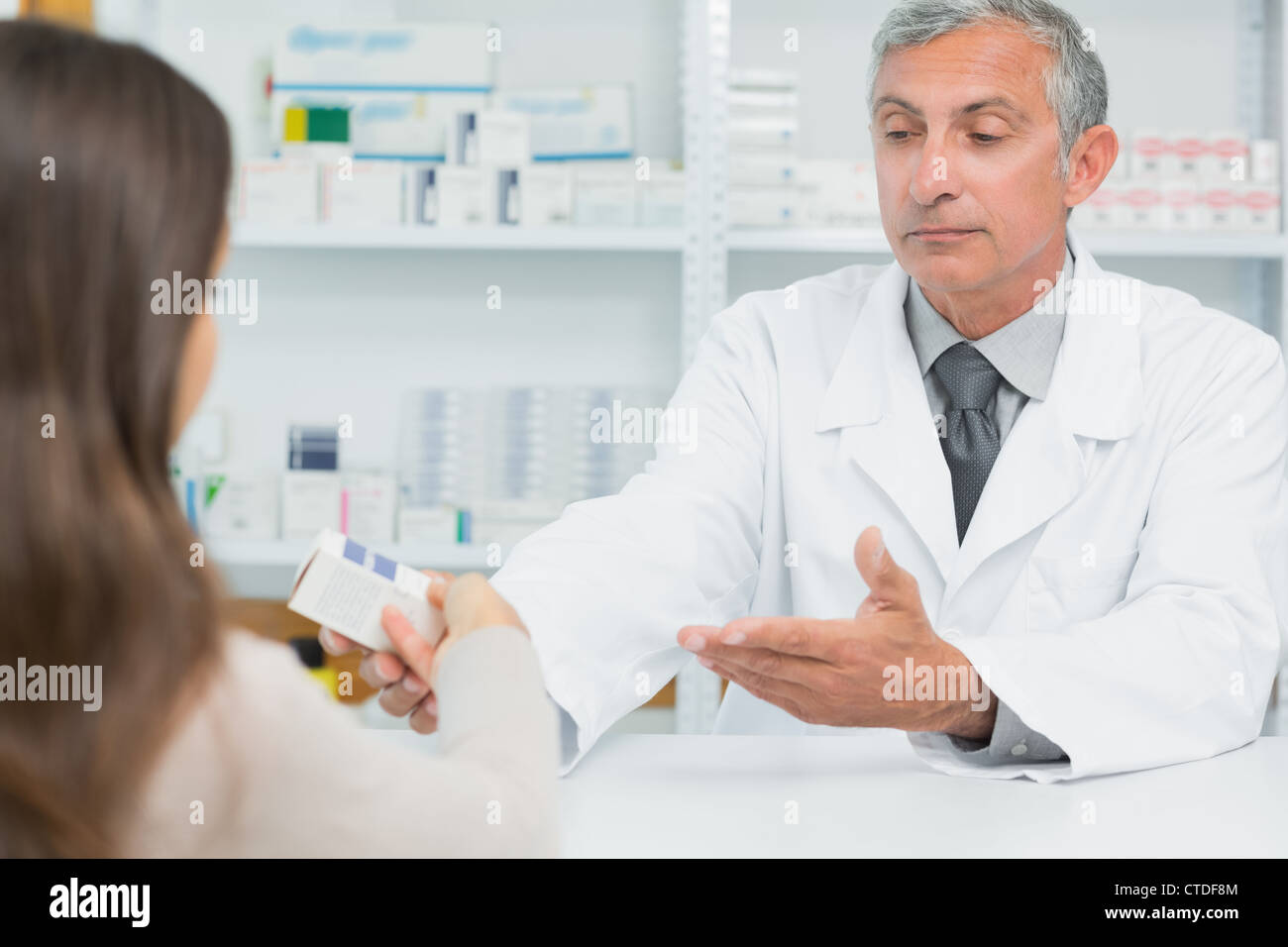 Pharmacist giving pills to a customer Stock Photo - Alamy