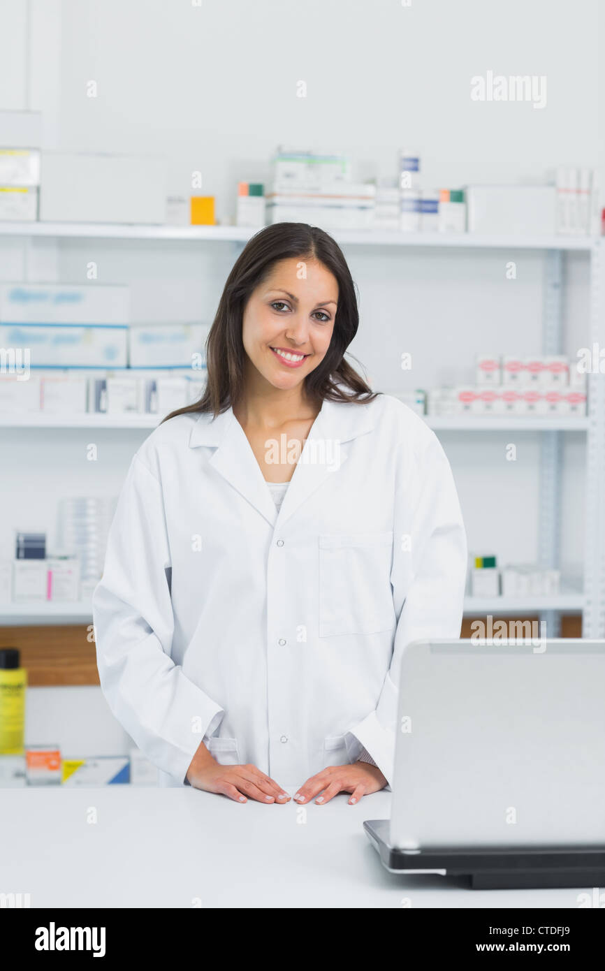 Smiling pharmacist standing behind the counter of a pharmacy Stock ...