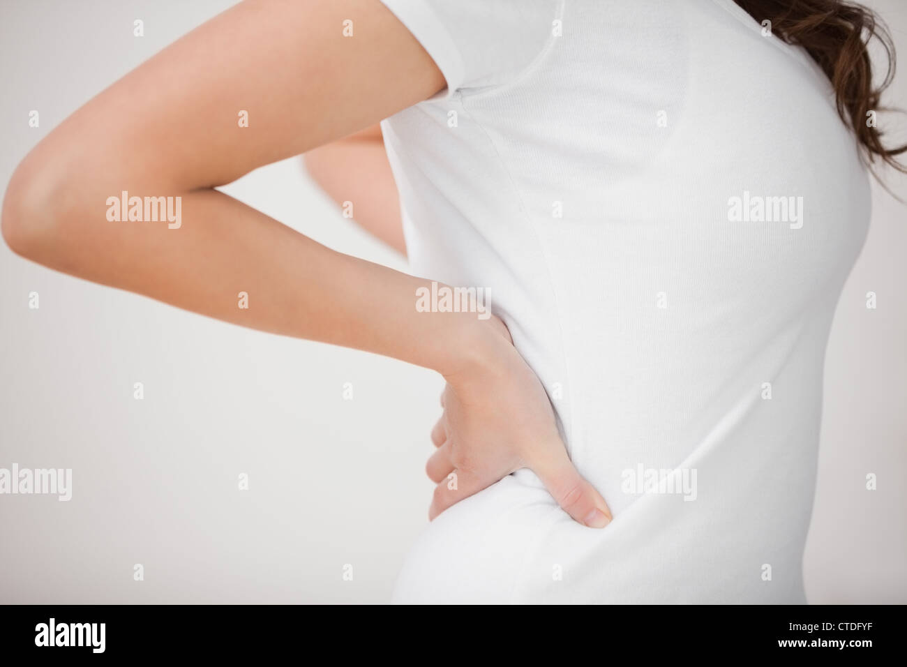 Woman putting her hands on her back Stock Photo - Alamy