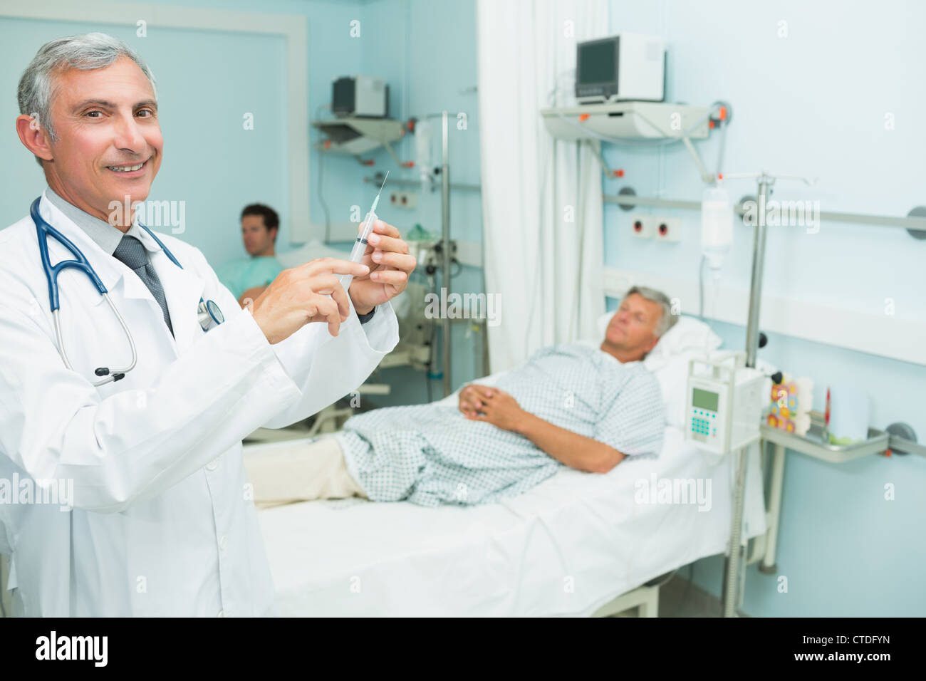 Happy doctor preparing an injection in a bed ward Stock Photo - Alamy