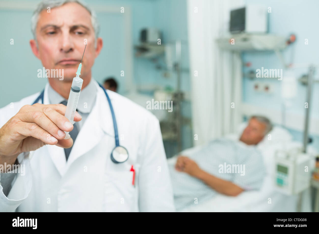 Serious doctor with an injection in his hands in a room Stock Photo - Alamy