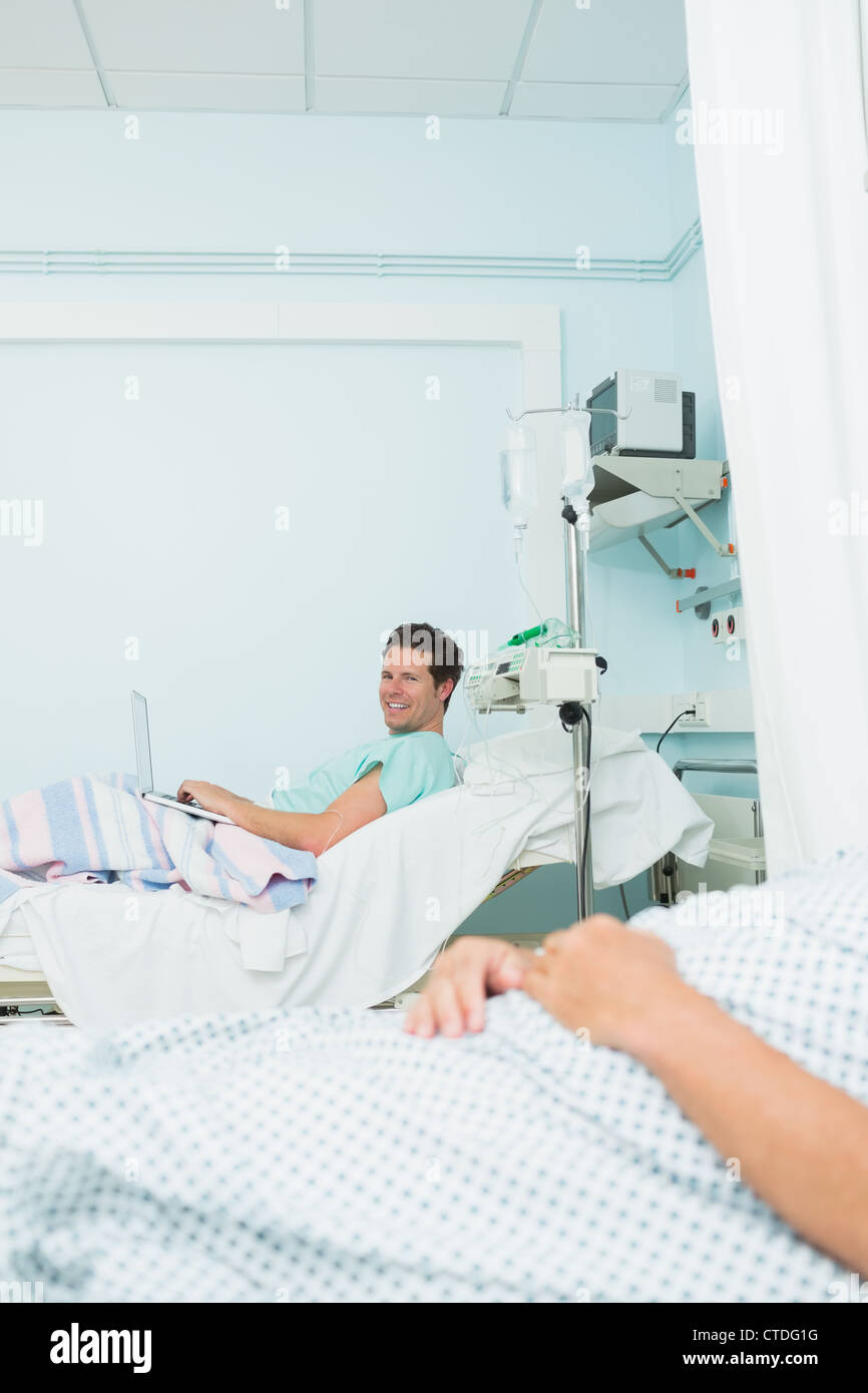 Smiling patient in a hospital room with an other patient Stock Photo ...