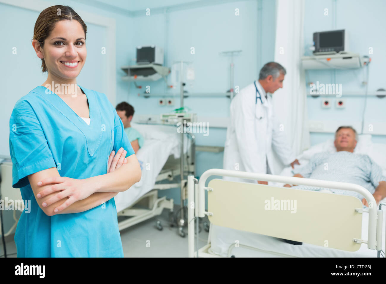 Smiling nurse standing in a bed ward Stock Photo - Alamy