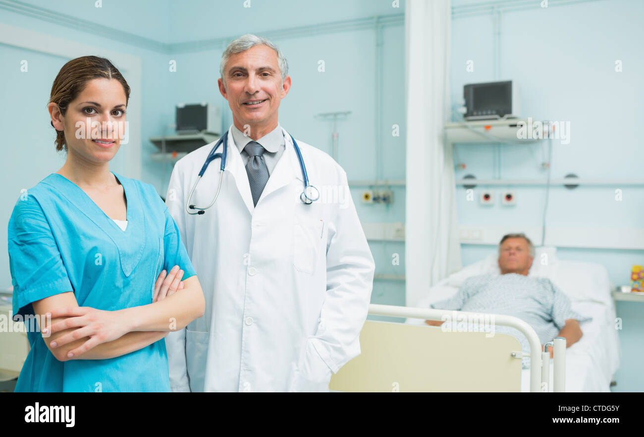 Doctor and nurse with her arms crossed standing in the room of a ...