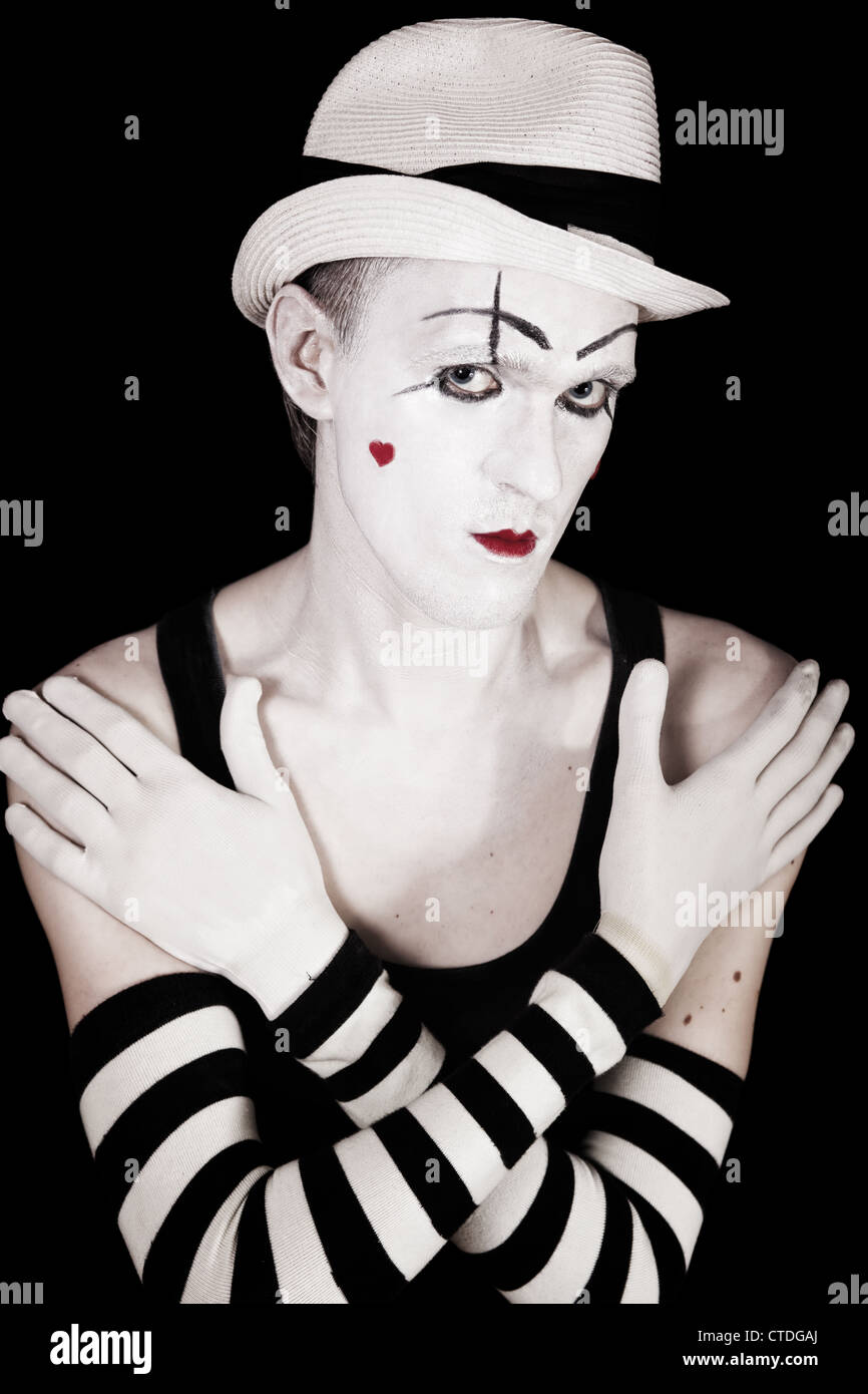 Studio portrait of mime in white hat and striped gloves isolated on ...