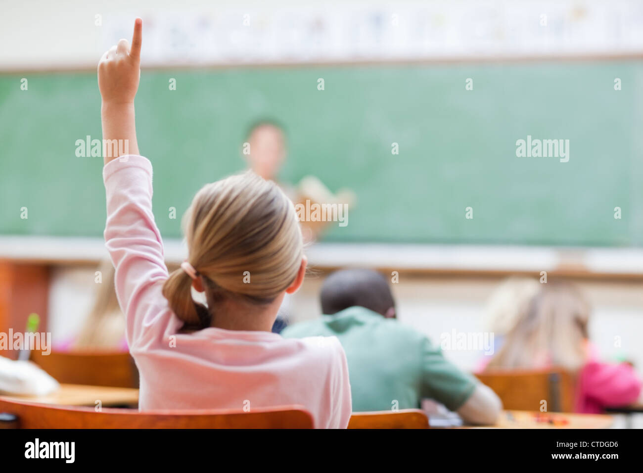 Elementary student with her hand raised Stock Photo - Alamy