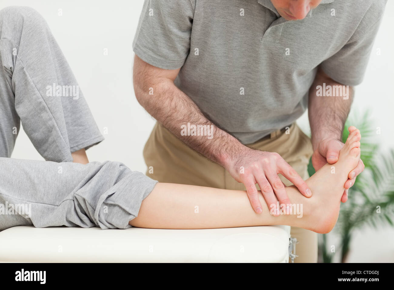 Doctor examining the foot of a woman Stock Photo - Alamy