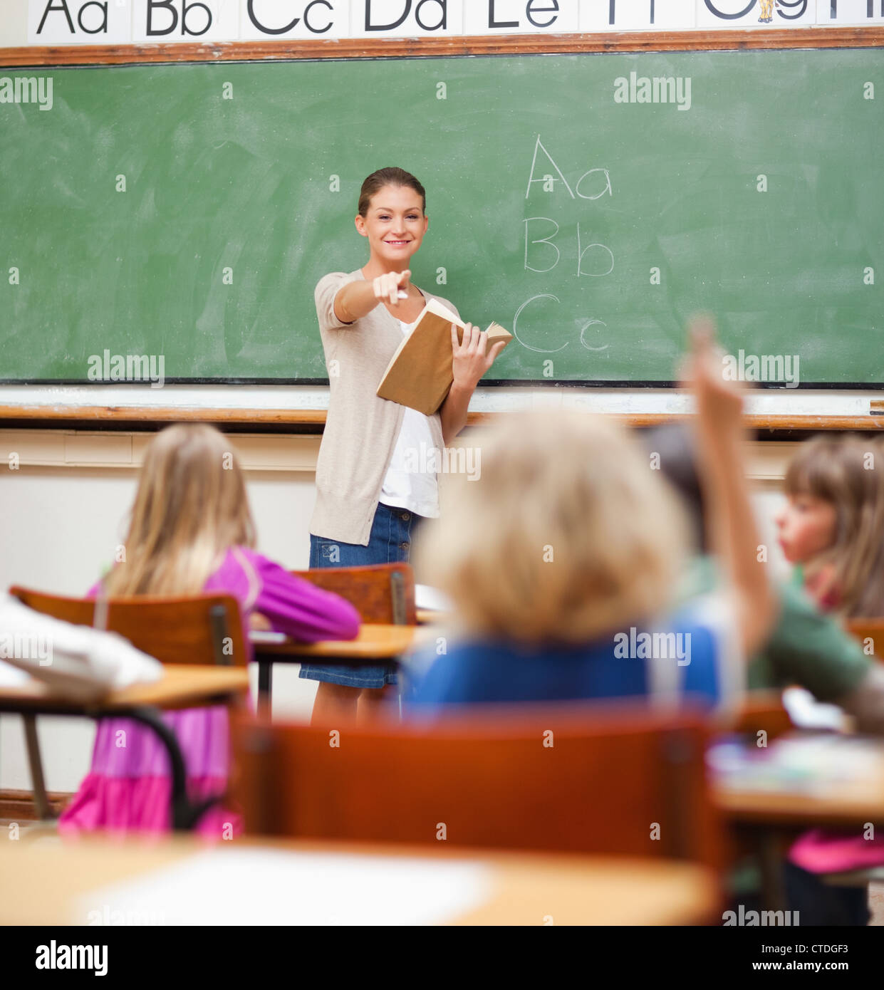 Teacher picking one of her students Stock Photo - Alamy