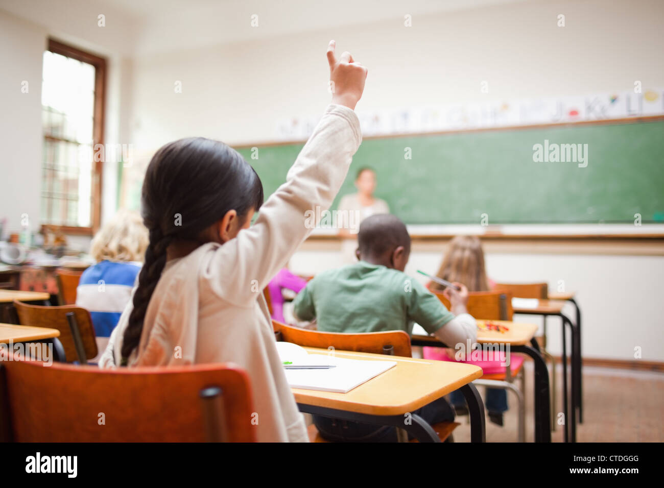 Back view schoolgirl raising hand hi-res stock photography and images ...