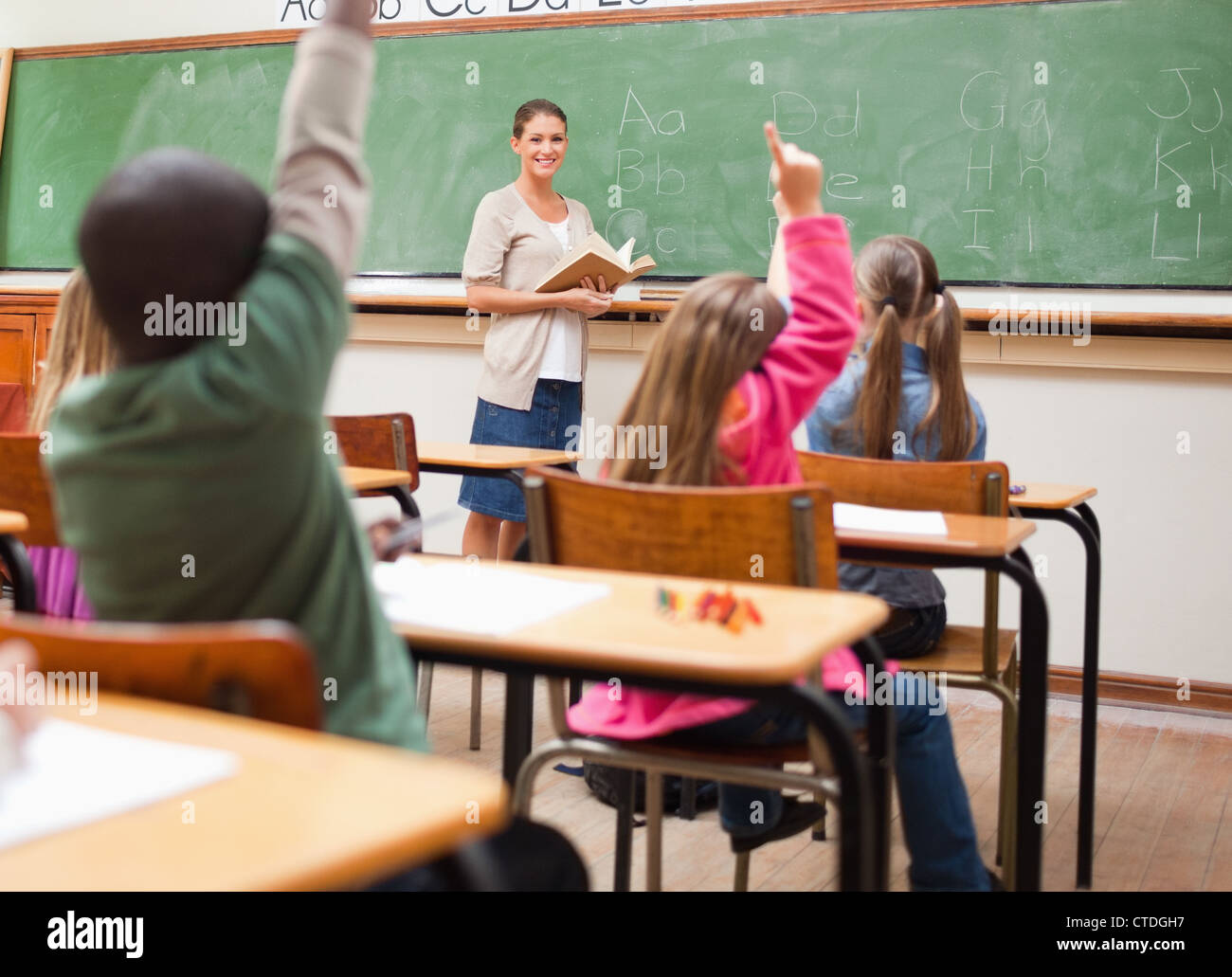 Back view of pupils raising hands Stock Photo - Alamy