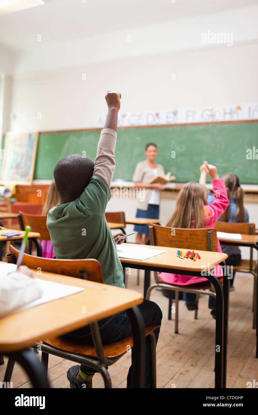 Back view of primary school students raising hands Stock Photo - Alamy