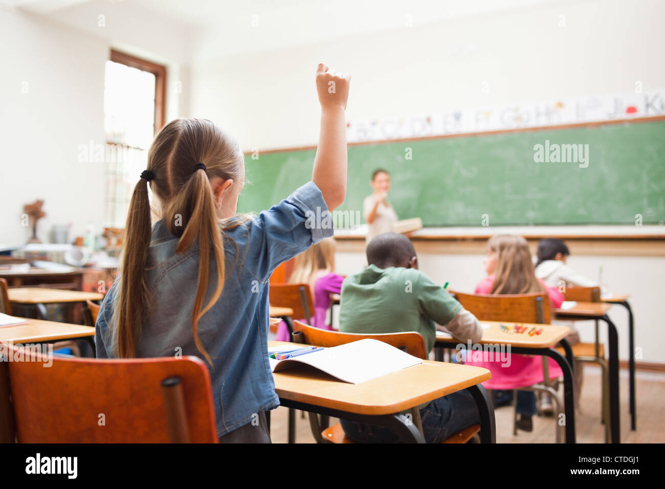 Back view schoolgirl raising hand hi-res stock photography and images ...