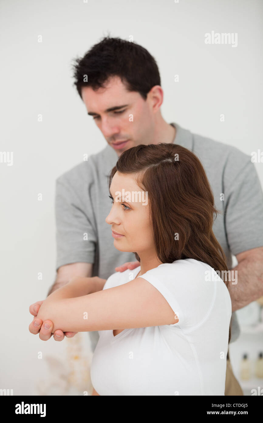 Serious doctor stretching the arm of a patient Stock Photo - Alamy