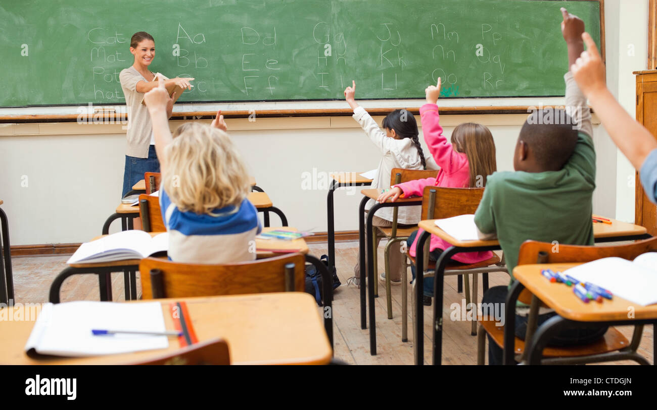 Back view of primary school class raising hands Stock Photo - Alamy