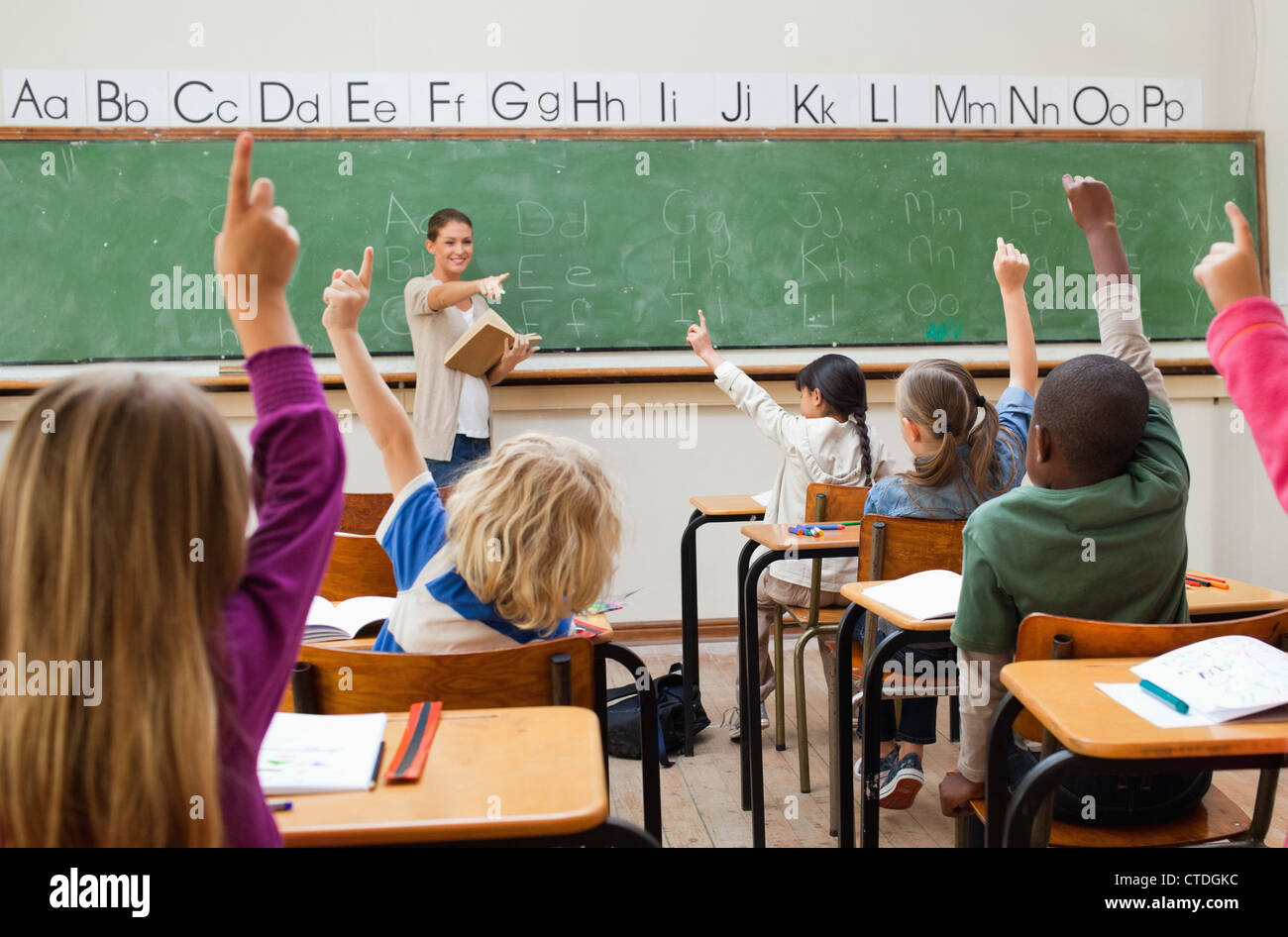 Teacher pointing boy raised hand hi-res stock photography and images ...