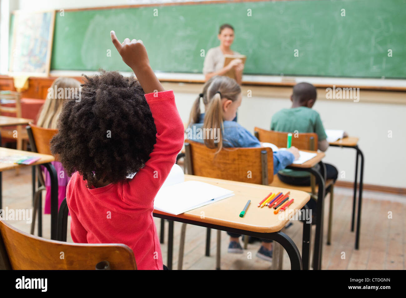 Back view schoolgirl raising hand hi-res stock photography and images ...