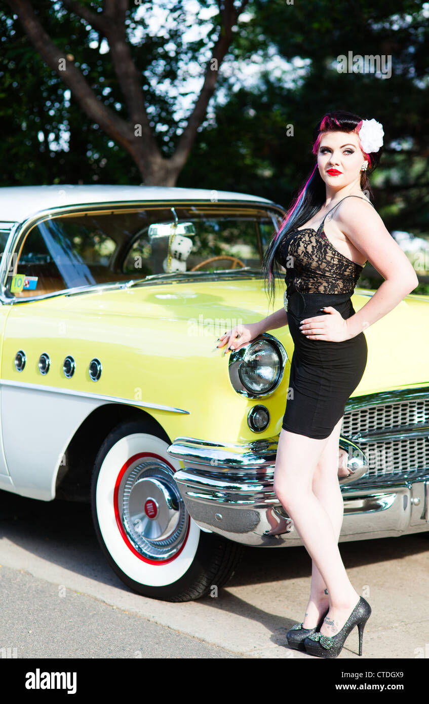 Female woman dressed in a rockabilly fashion posing next to a classic ...