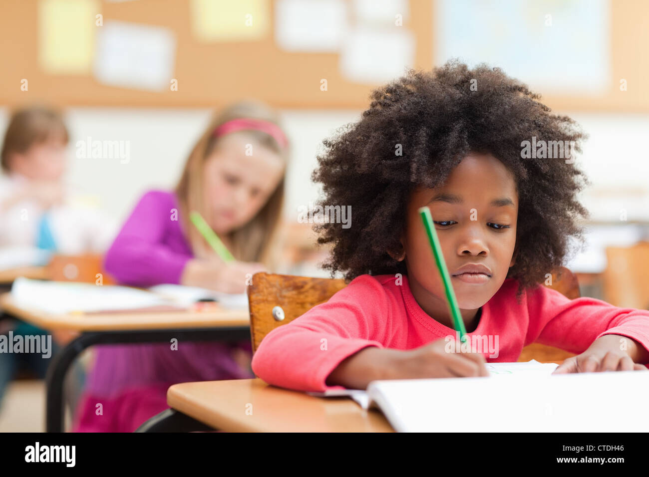 Girl writing down into her book Stock Photo - Alamy