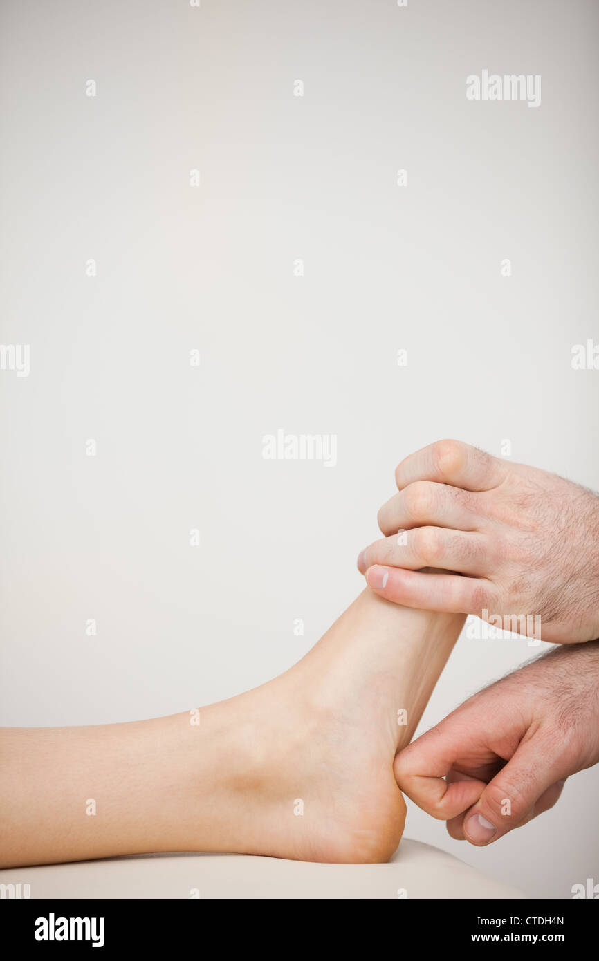 Chiropodist using his index finger to massage a foot Stock Photo - Alamy