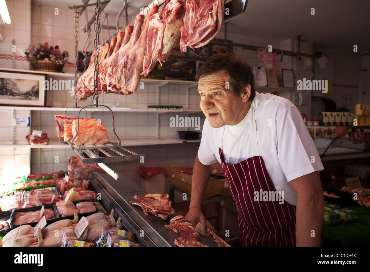 Harry the butcher looks out of his meat shop ready for the day Stock ...