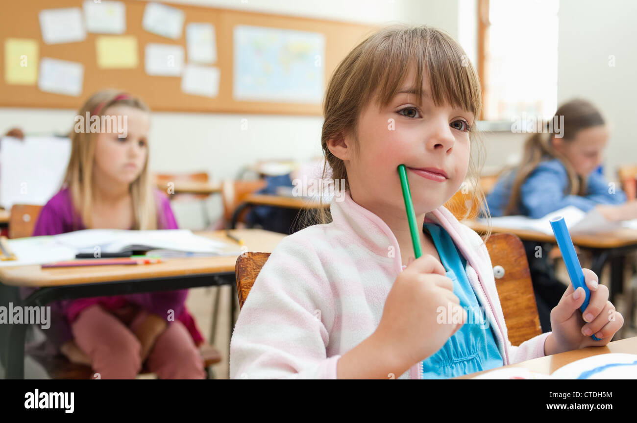 Thoughtful girl sitting in first row in class Stock Photo - Alamy