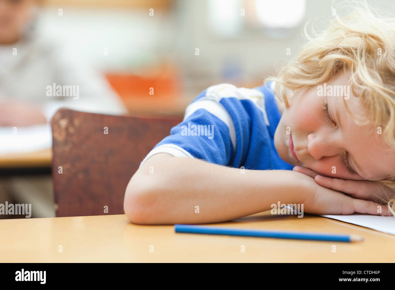 Boy taking a nap on his desk Stock Photo - Alamy
